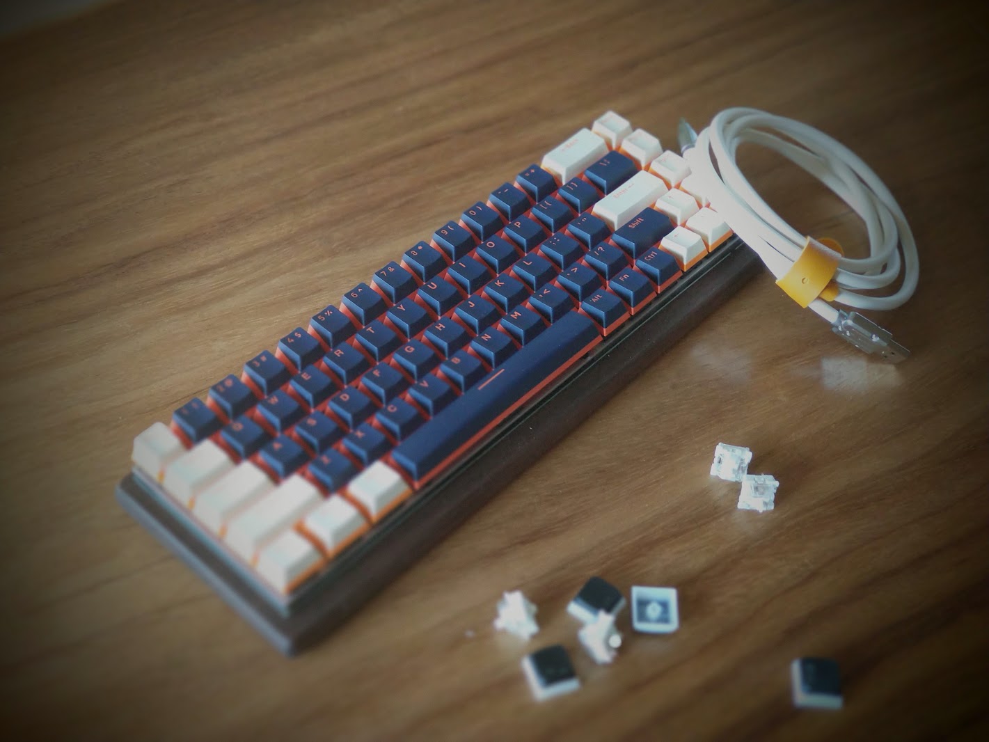 65% wooden mechanical keyboard with a dark walnut backplate and white ...